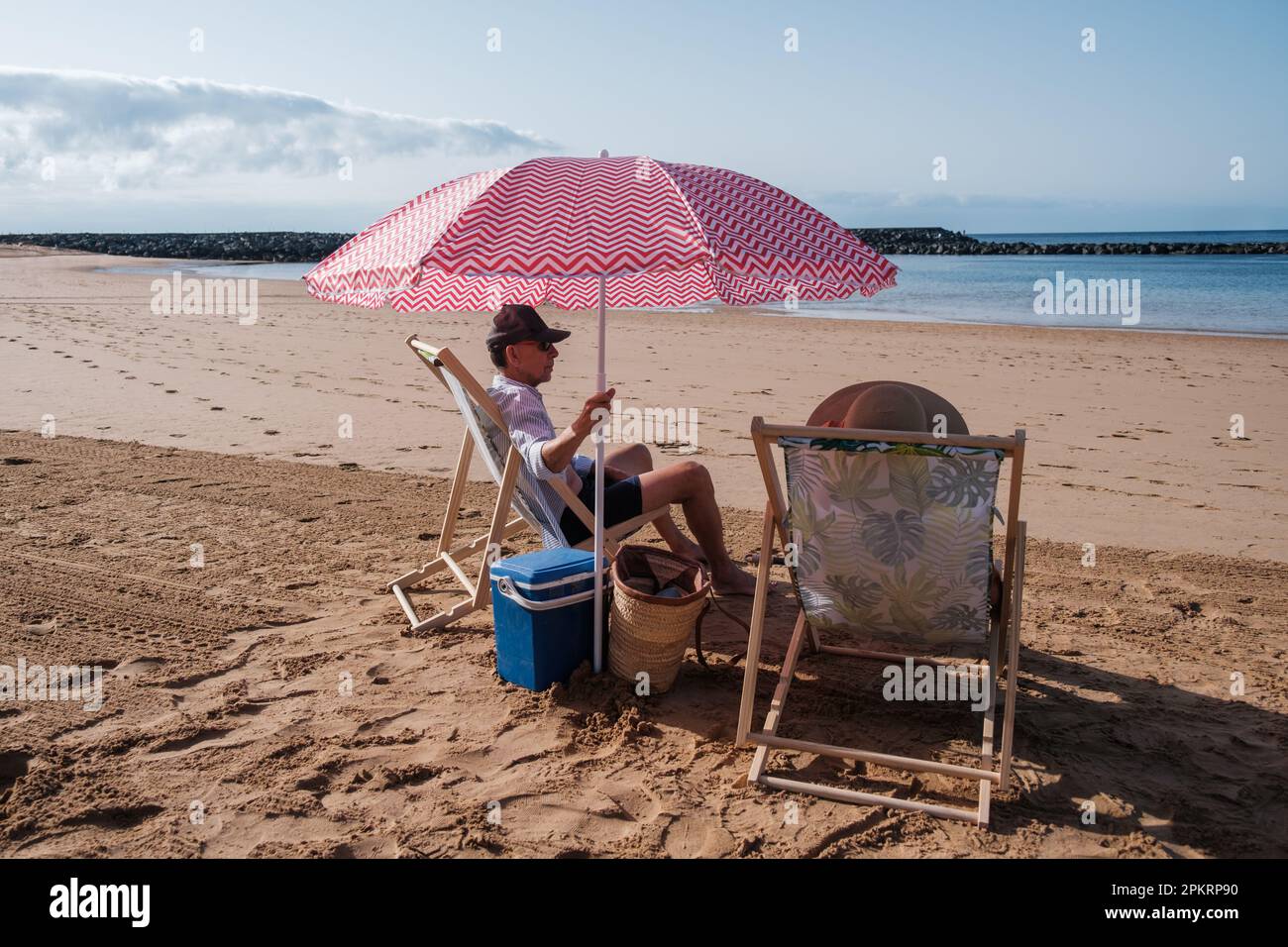 Retired couple taking a place on the beach to spend a day of rest in ...