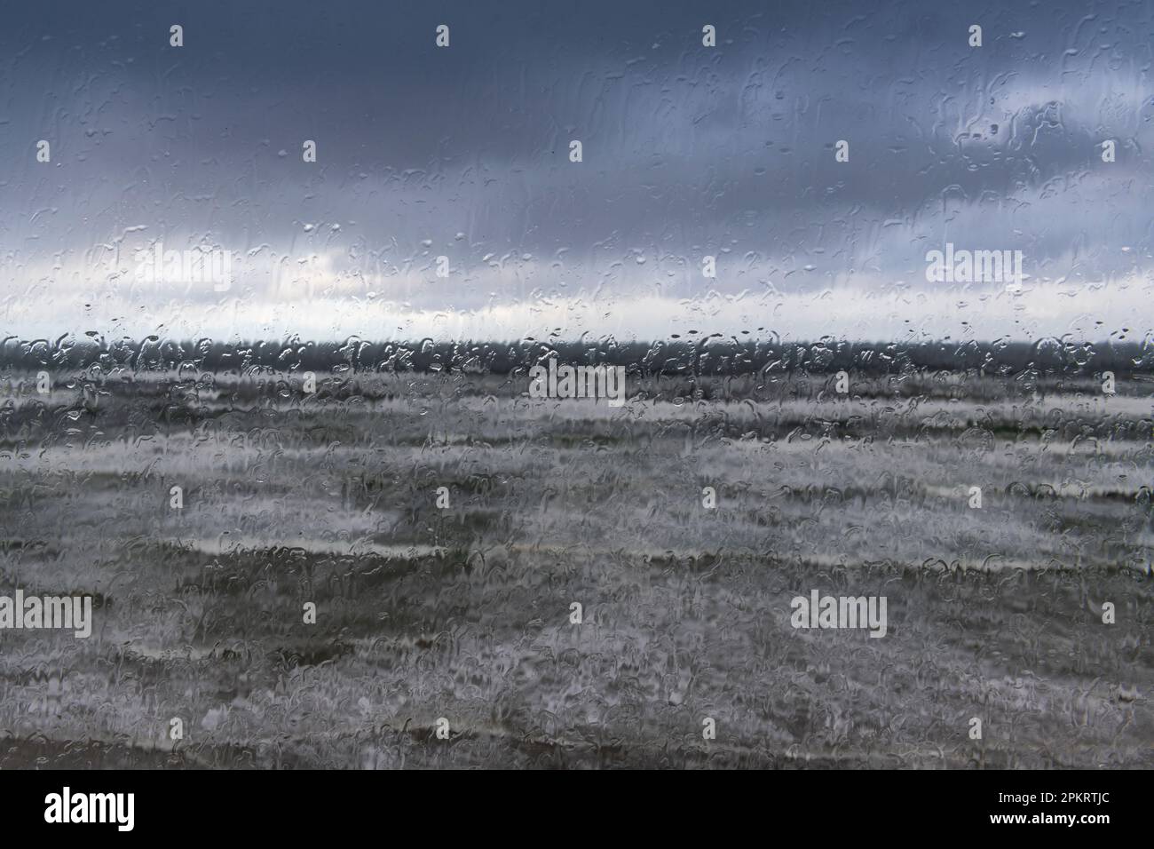 Rain drops crush against window and run down the glass during stormy ...