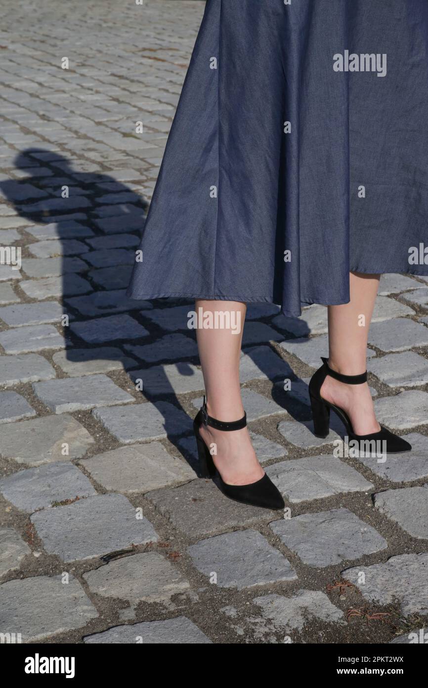 Woman in midi blue dress and pointed toe pumps with block high heels ...