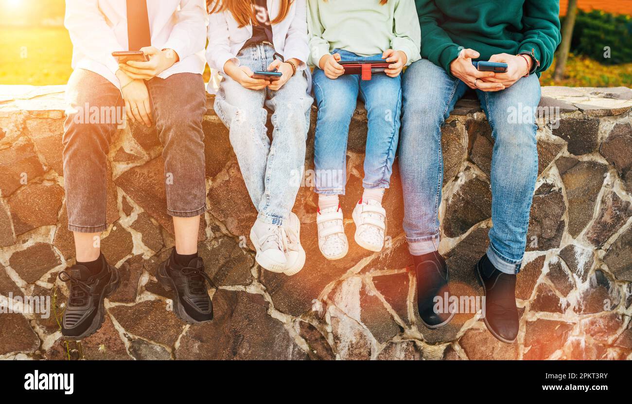 Friends boy and a girl Kids sitting and browsing their smartphone ...