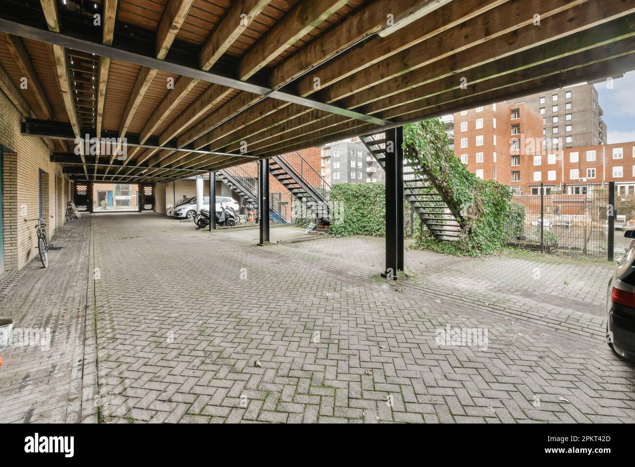 an empty parking area with cars parked on the side and buildings in the ...