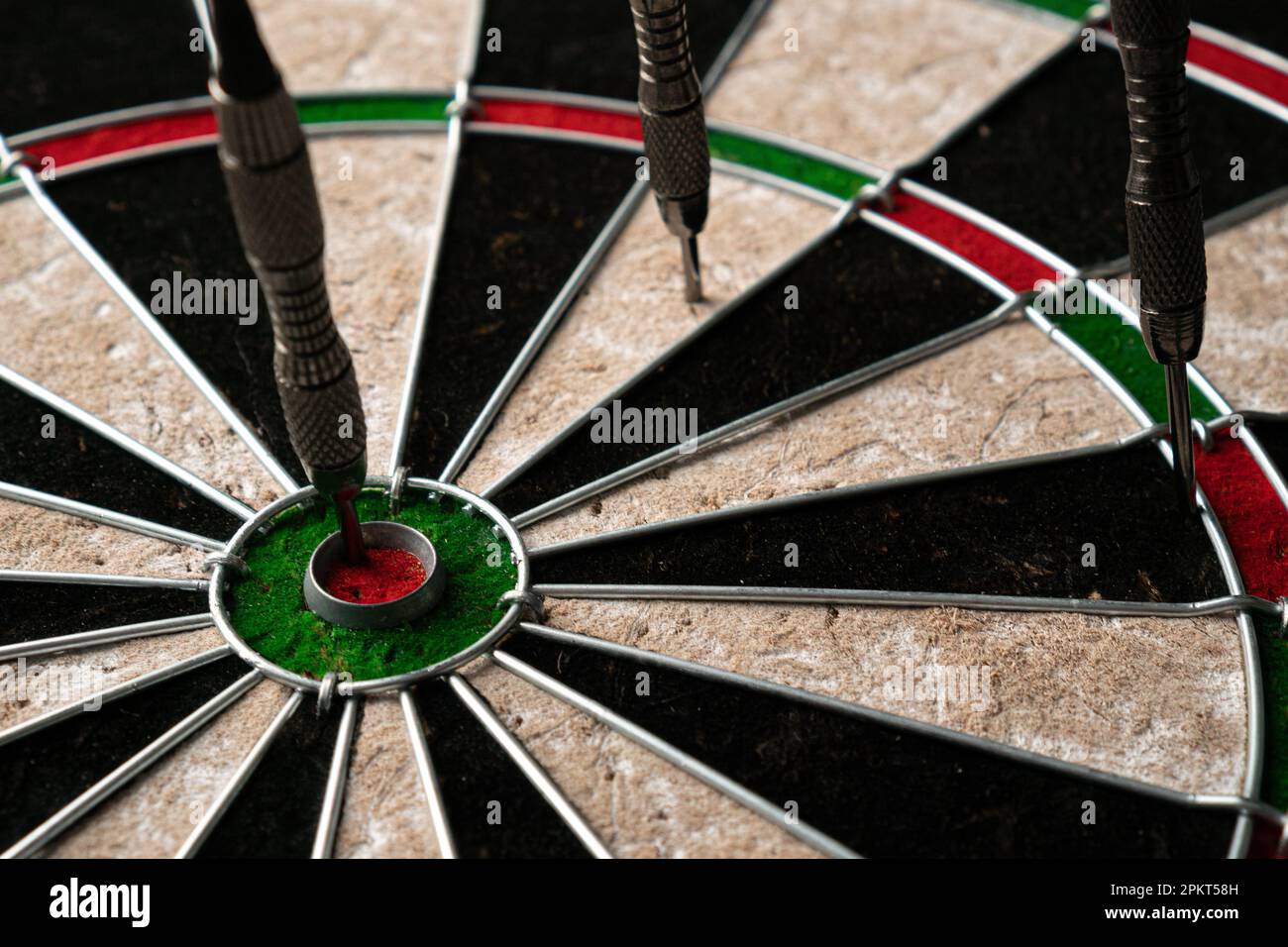 Three darts hit the dartboard. Lucky - one of the darts hits the bull's ...