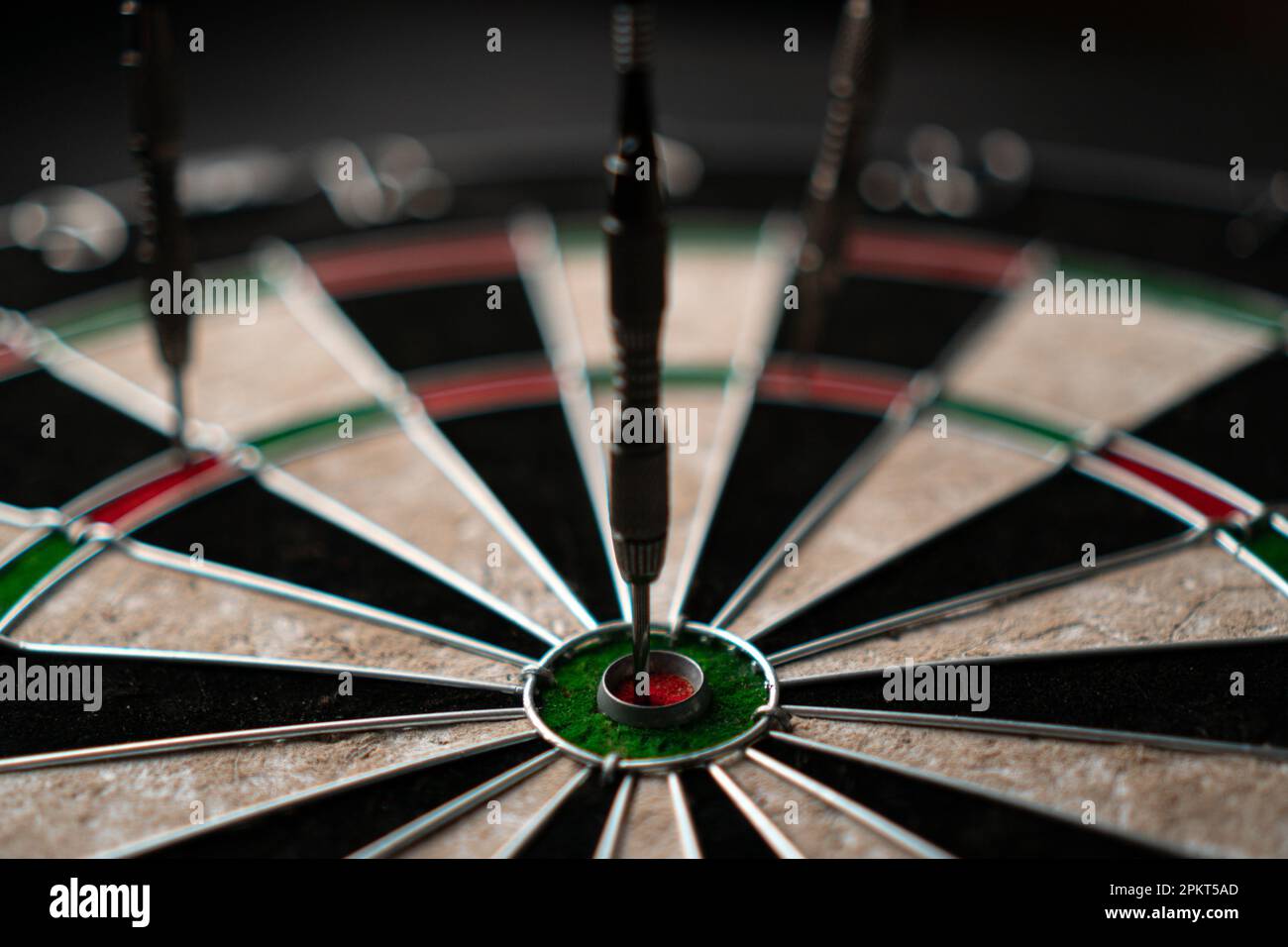 Three darts hit the dartboard. Lucky - one of the darts hits the bull's ...
