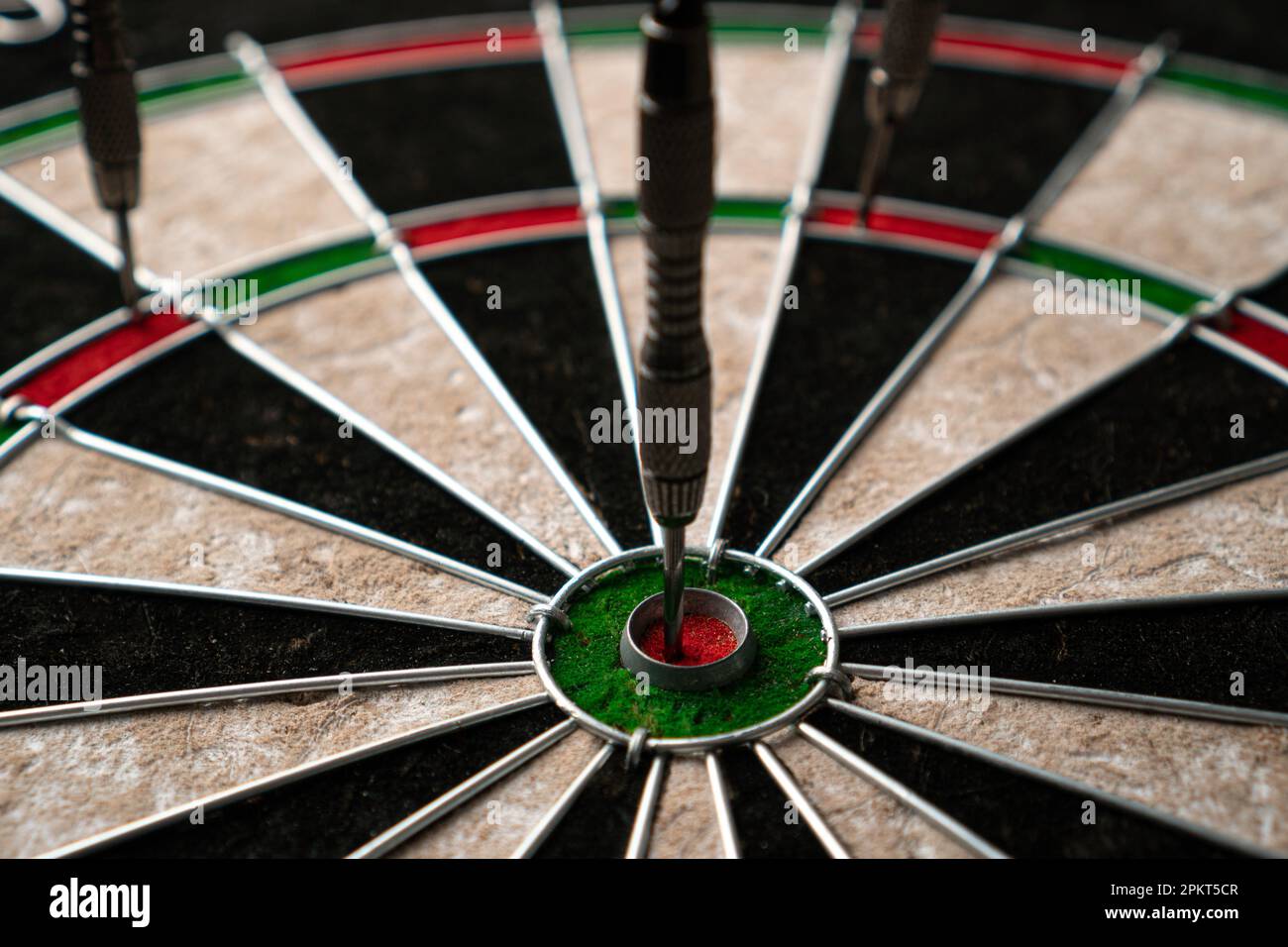 Three darts hit the dartboard. Lucky - one of the darts hits the bull's ...