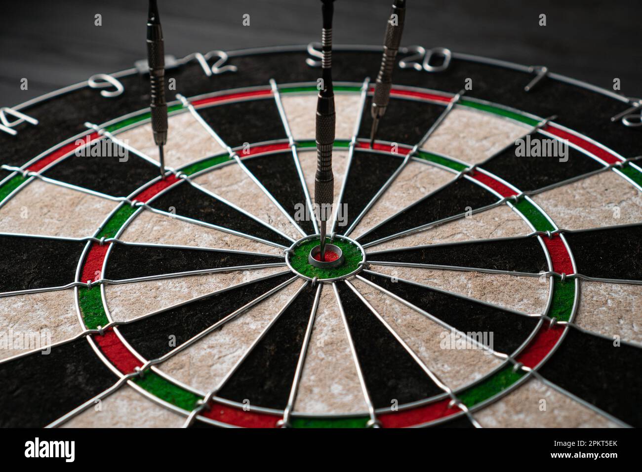 Three darts hit the dartboard. Lucky - one of the darts hits the bull's ...