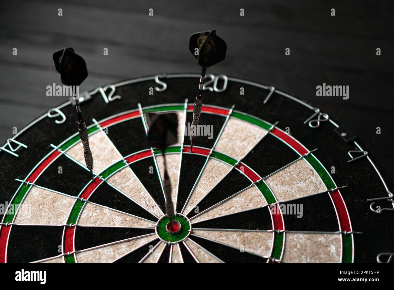 Three darts hit the dartboard. Lucky - one of the darts hits the bull's ...