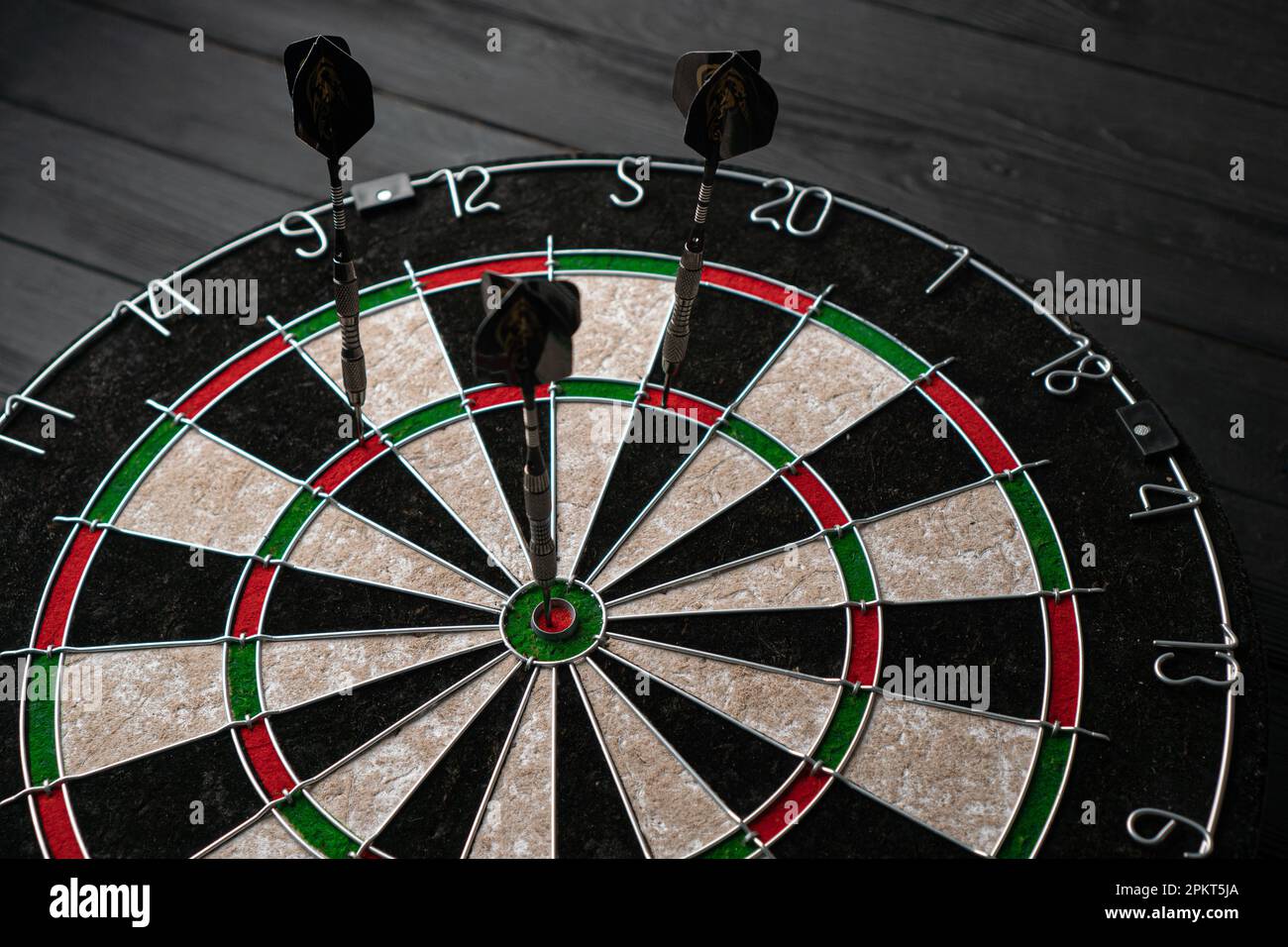 Three darts hit the dartboard. Lucky - one of the darts hits the bull's ...