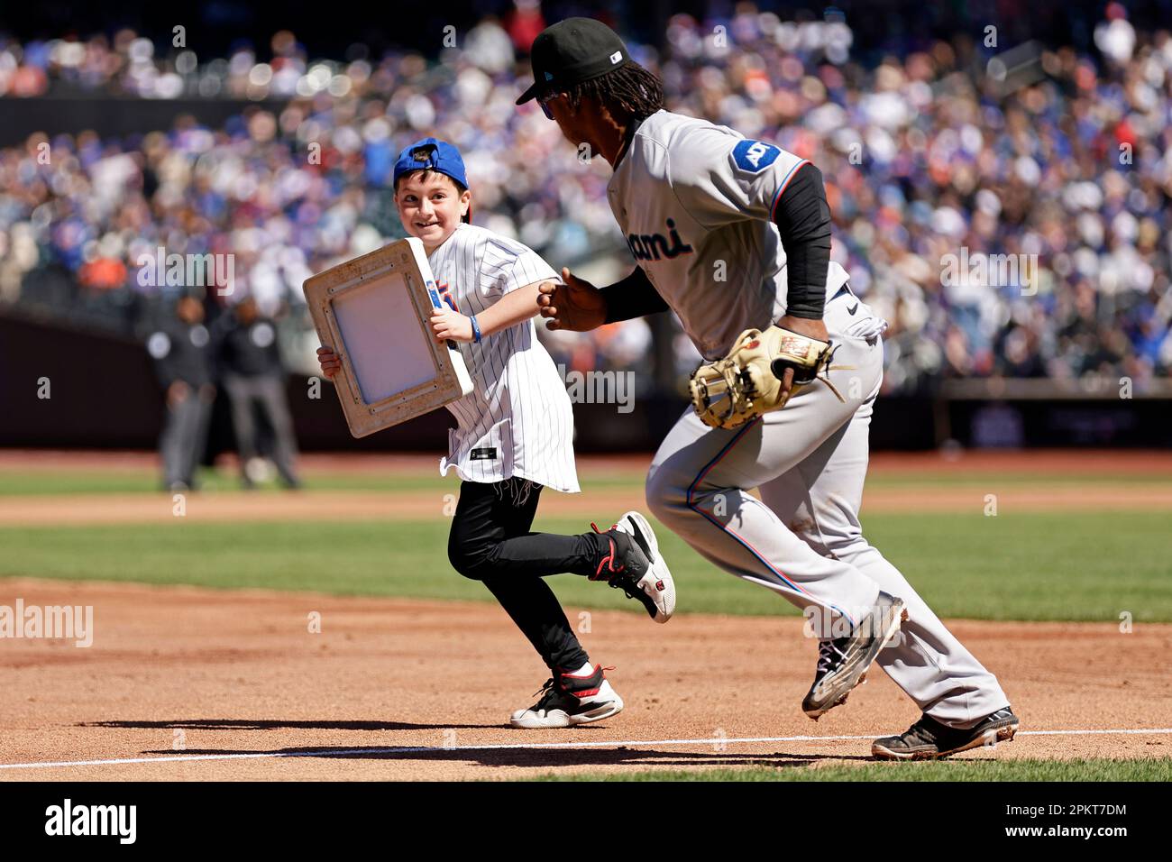 Miami Marlins third baseman Jean Segura pretends to race a young fan in ...
