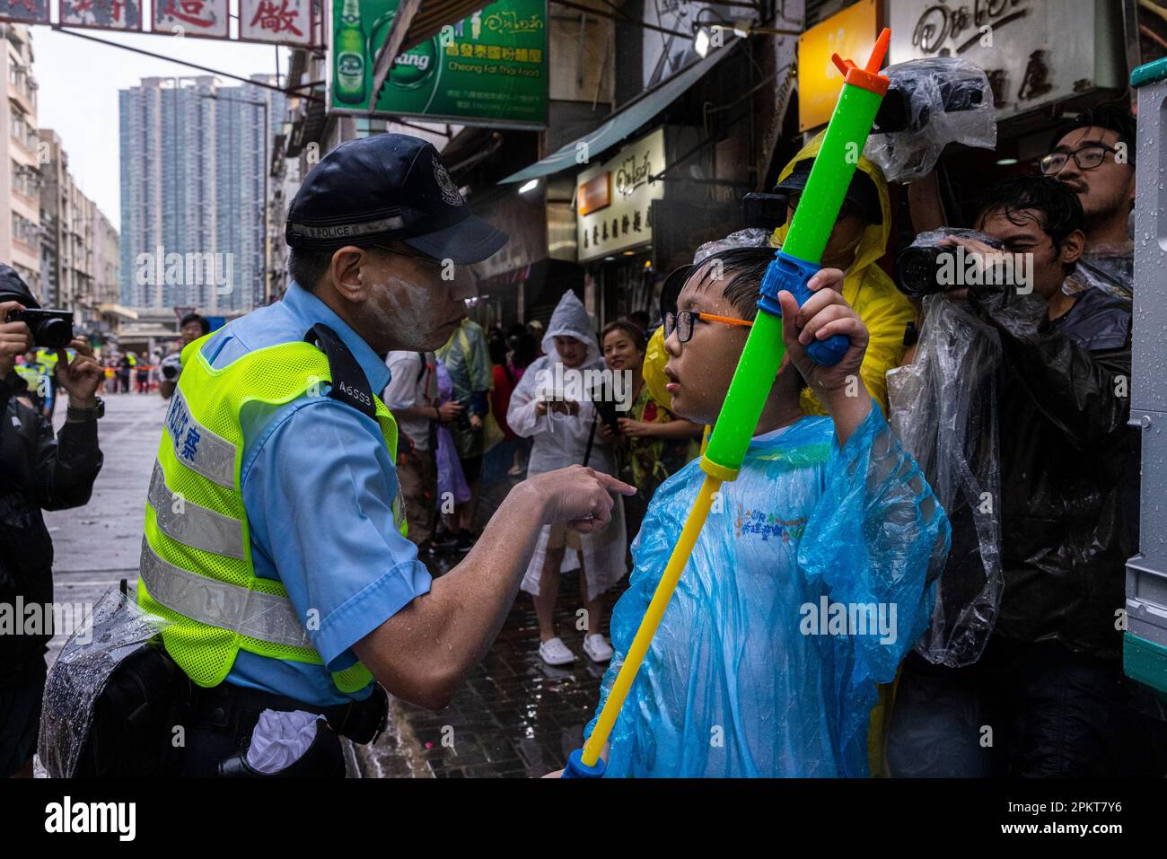 A police officer gives instructions to revellers taking part in a water ...