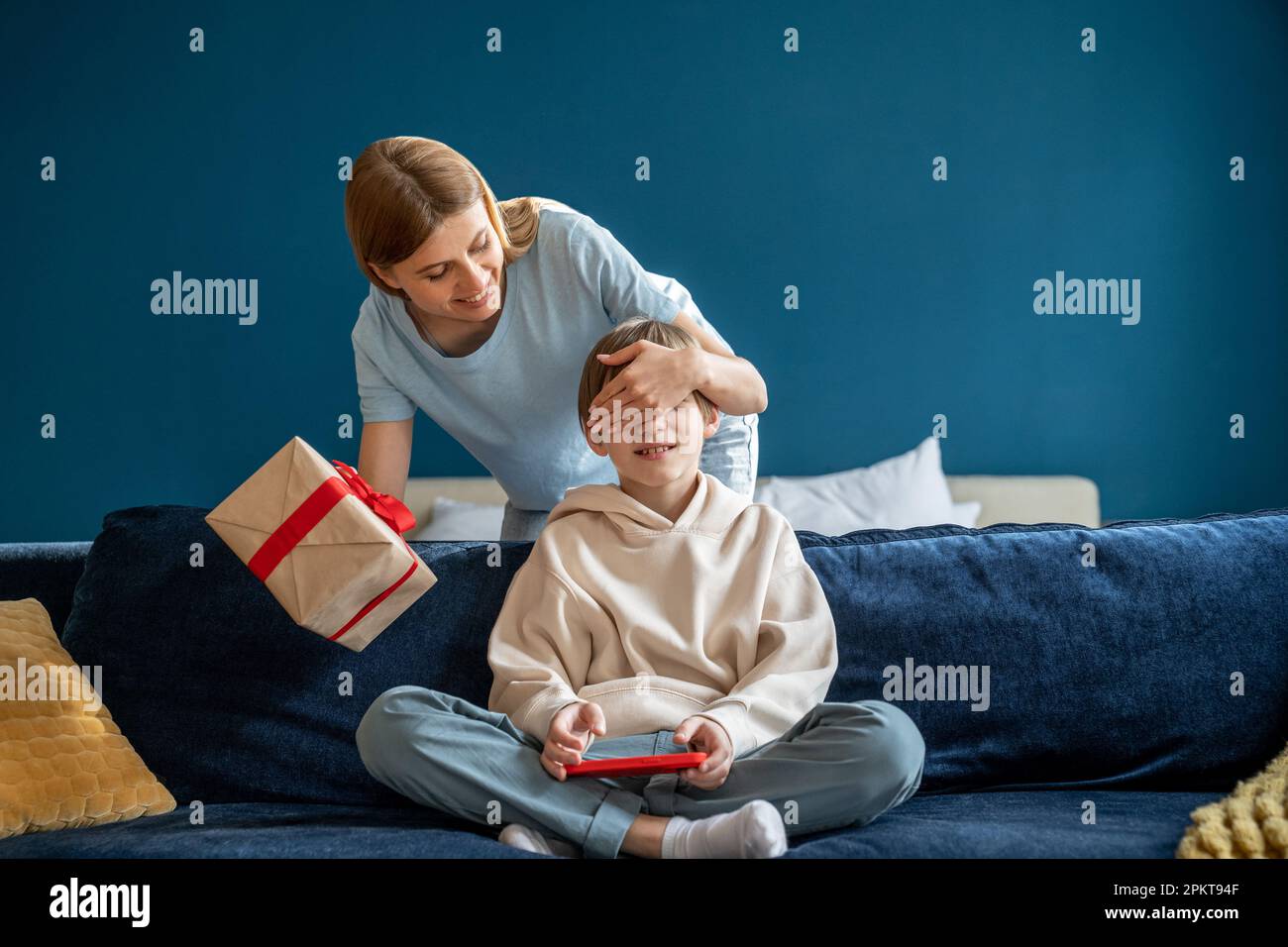 Young happy loving mother closing eyes of child son congratulating ...