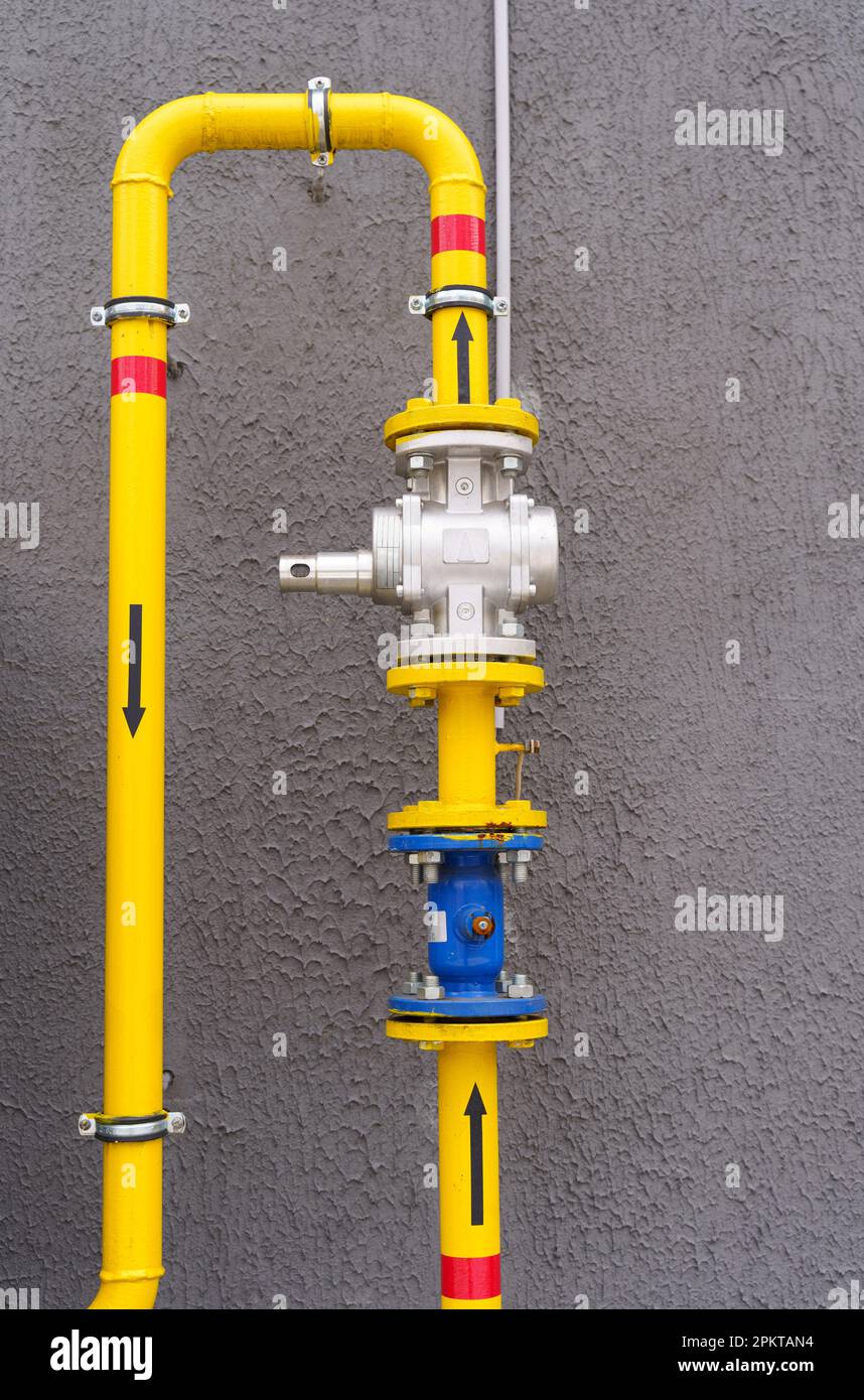 Yellow gas pipe with a shut-off - turn-on valve, connected to the wall ...