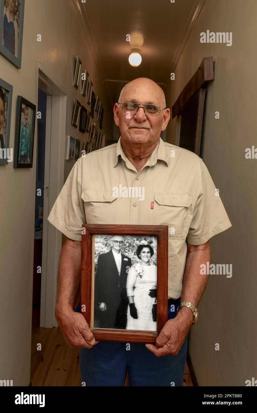 78 year farmer Gert Strydom of the Haarlem district holds up a portrait ...