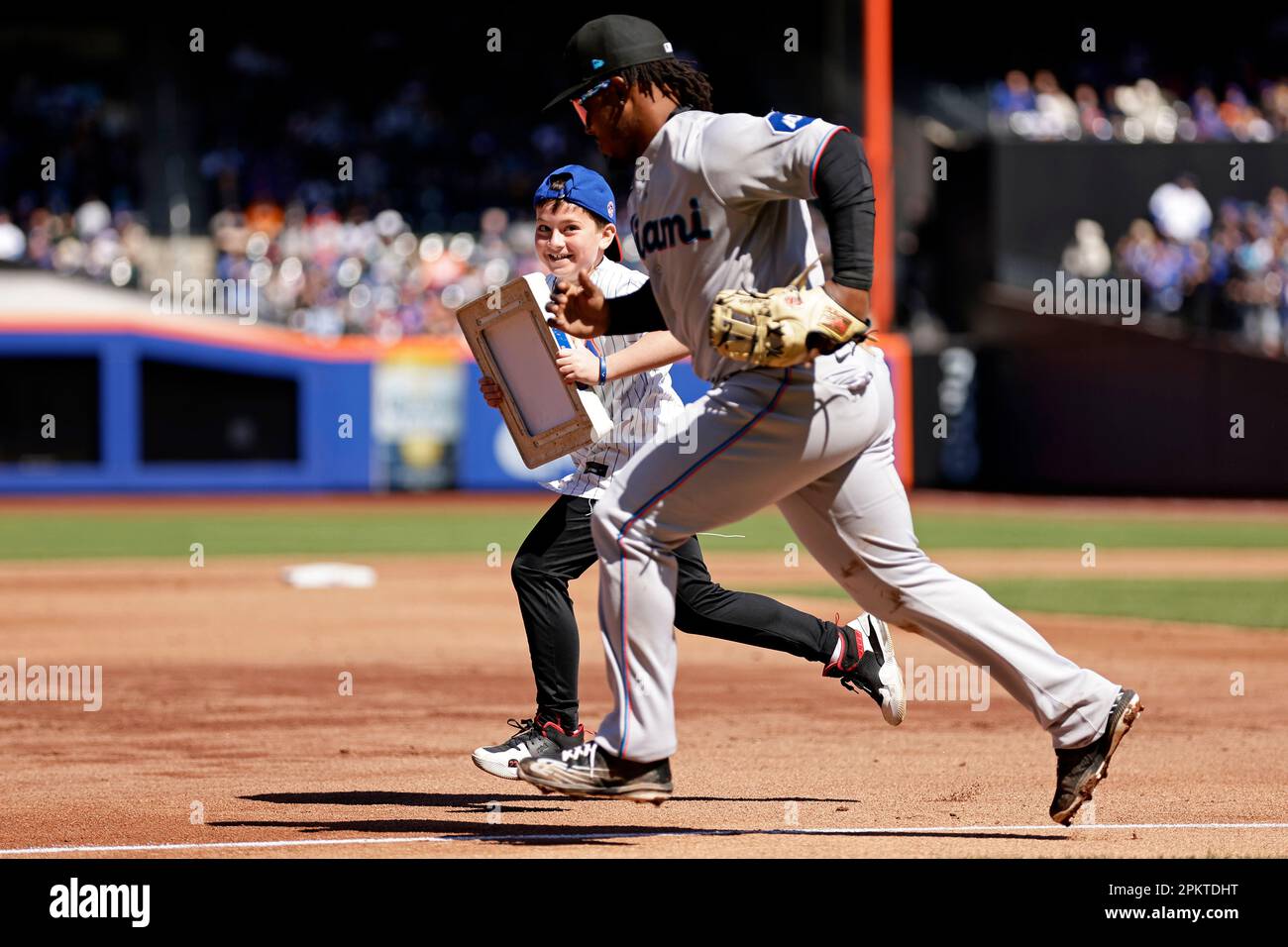 Miami Marlins third baseman Jean Segura pretends to race a young fan in ...