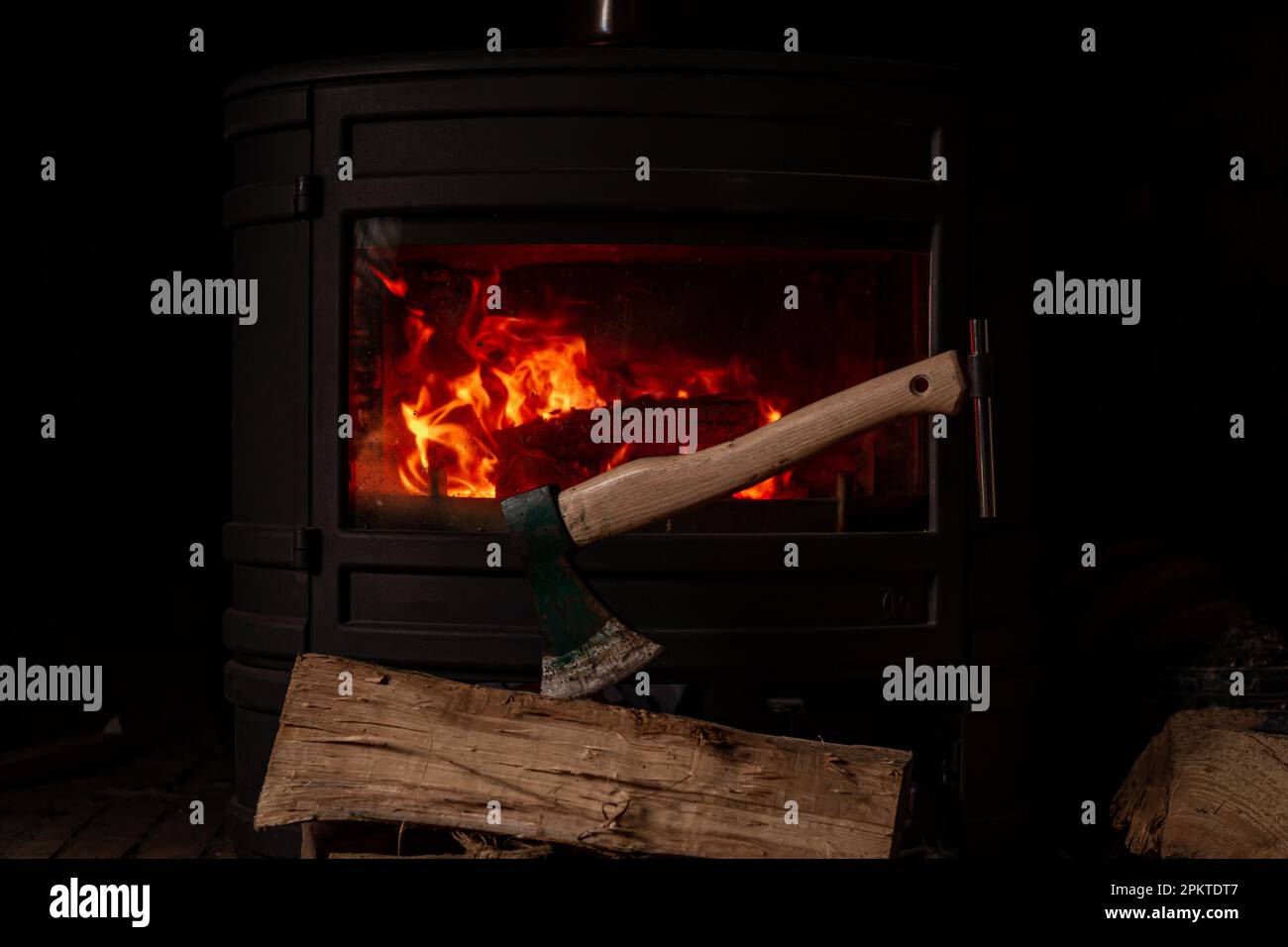 Axe with log on background of burning fireplace. Wood heating, firewood ...