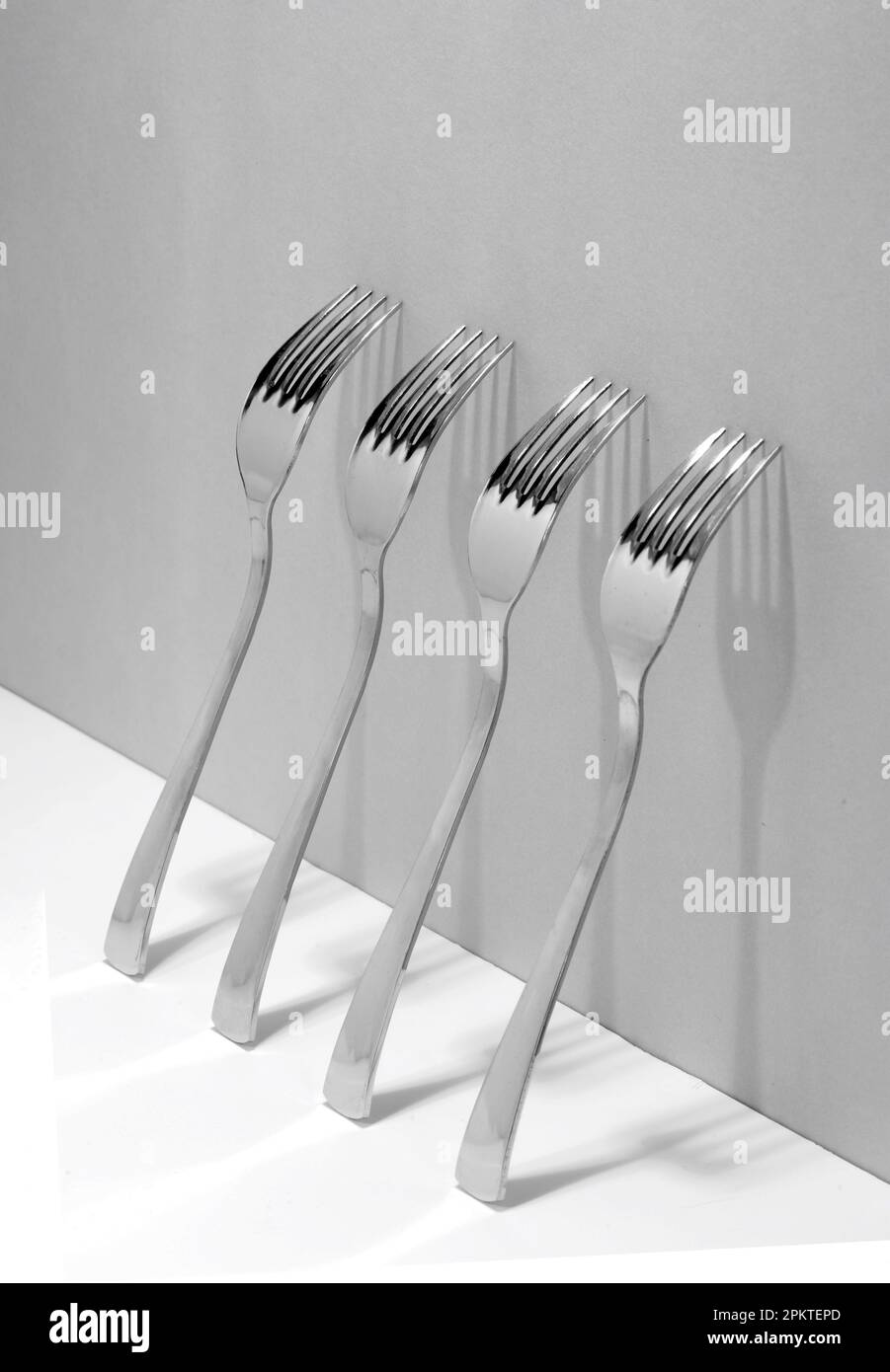 stainless steel forks and symmetrically mirror reflection on a white ...