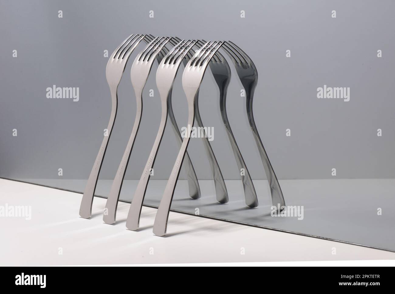 stainless steel forks and symmetrically mirror reflection on a white ...