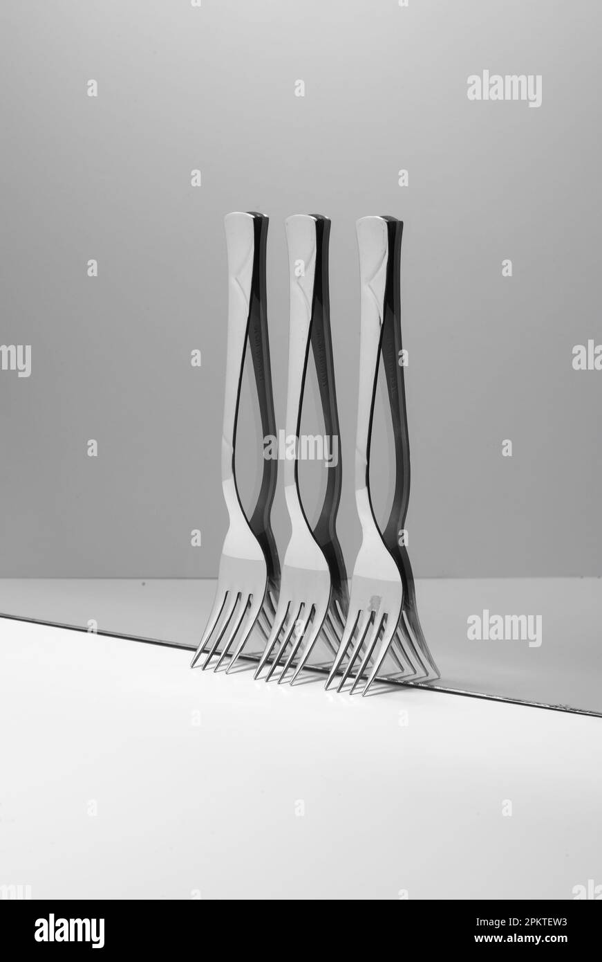 stainless steel forks and symmetrically mirror reflection on a white ...