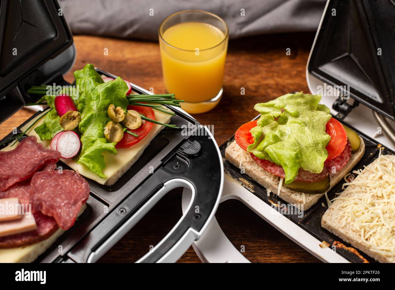 Different types of sandwiches in a sandwich maker on a wooden ...