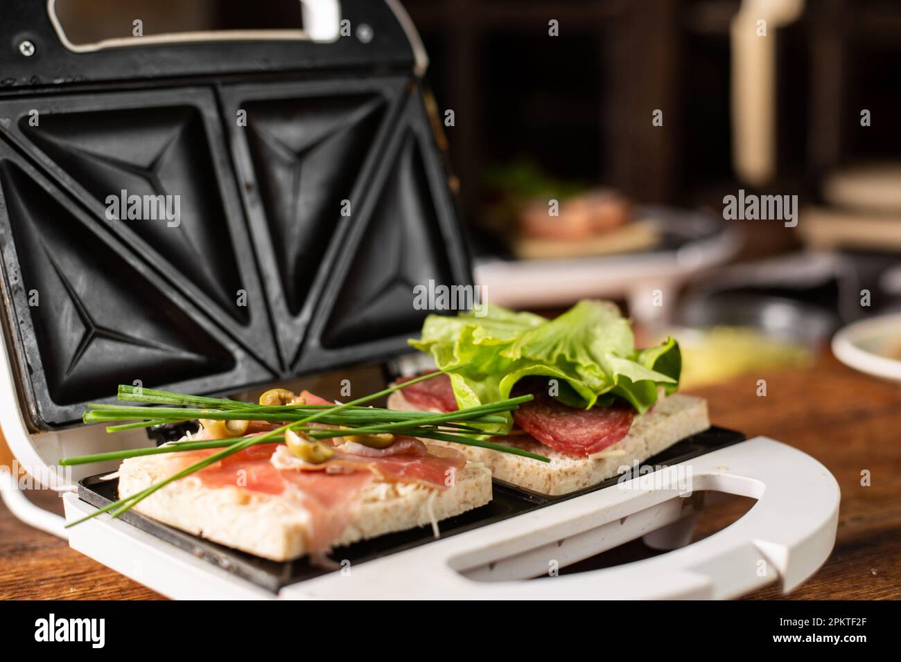 Making sandwiches from ham, vegetables and cheese in a sandwich maker ...