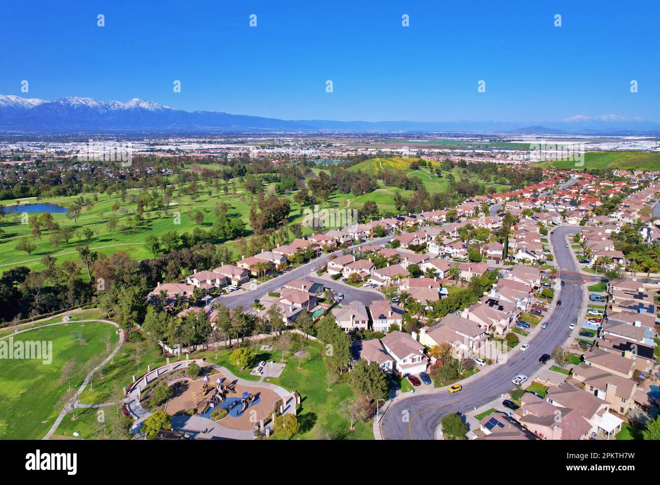 Aerial view of lush green grass and trees, with a backdrop of mountains ...