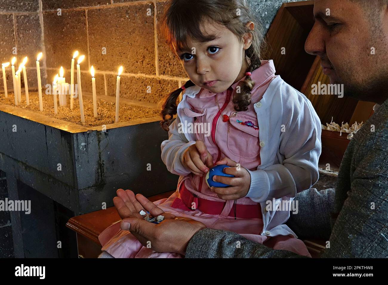A girl peels the egg she won from her friend in the traditional egg ...
