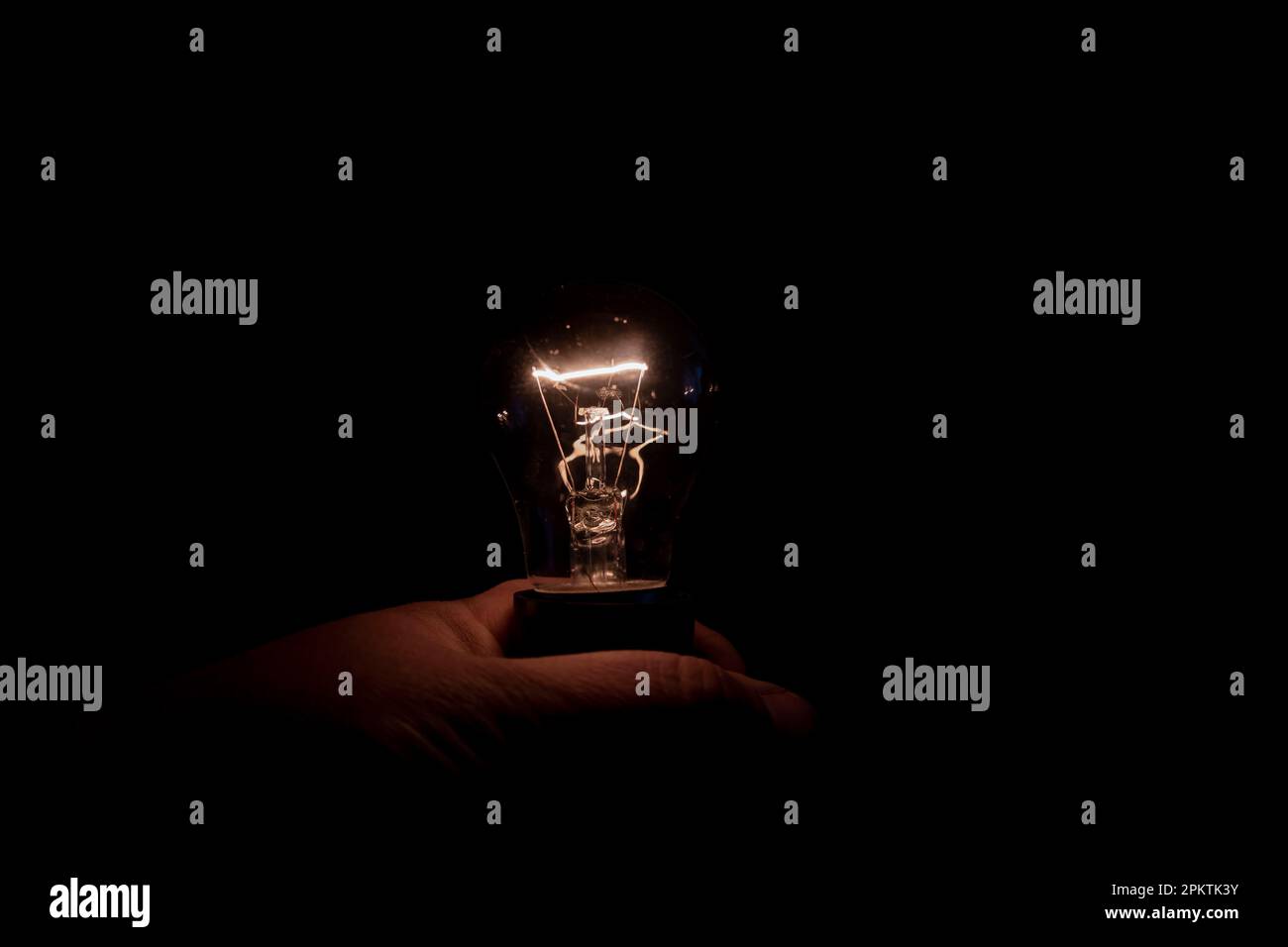 The light from the incandescent lamp in the hands Stock Photo - Alamy