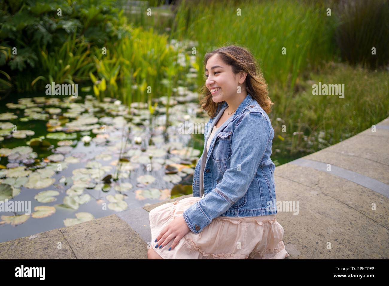 Female Asian Teen Seated Beside a Lily Pond | De Young Museum Stock ...
