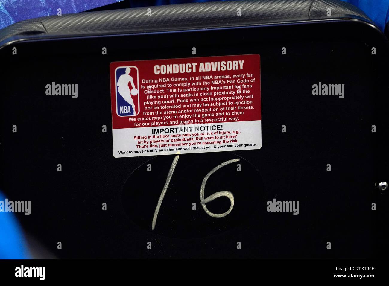 A floor seat carries a conduct advisory for fan during an NBA ...