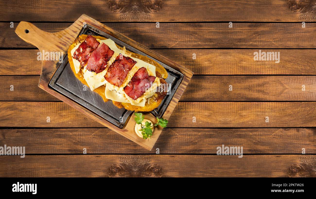 Green plantain patacon with shredded chicken, cheese and bacon ...