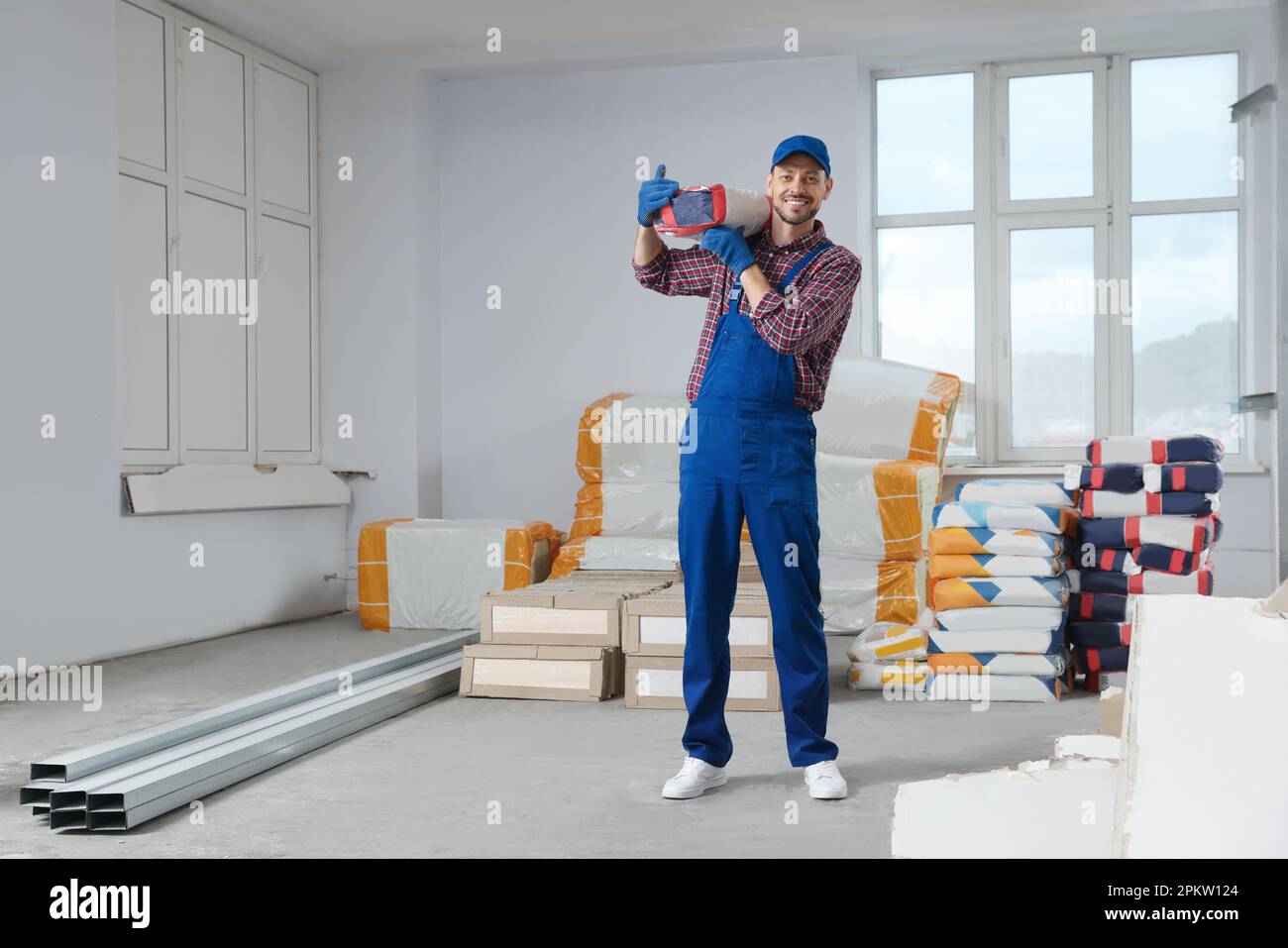 Construction worker with new building materials in room prepared for ...