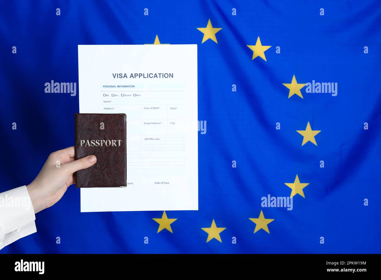 Woman holding visa application form and passport against European Union ...