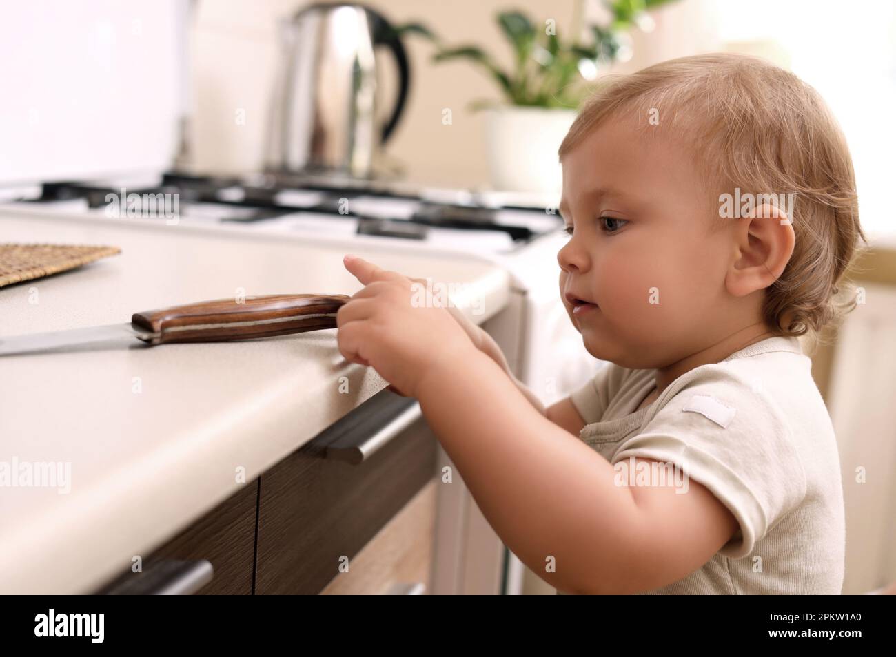 Little child touching sharp knife indoors. Dangers in kitchen Stock ...