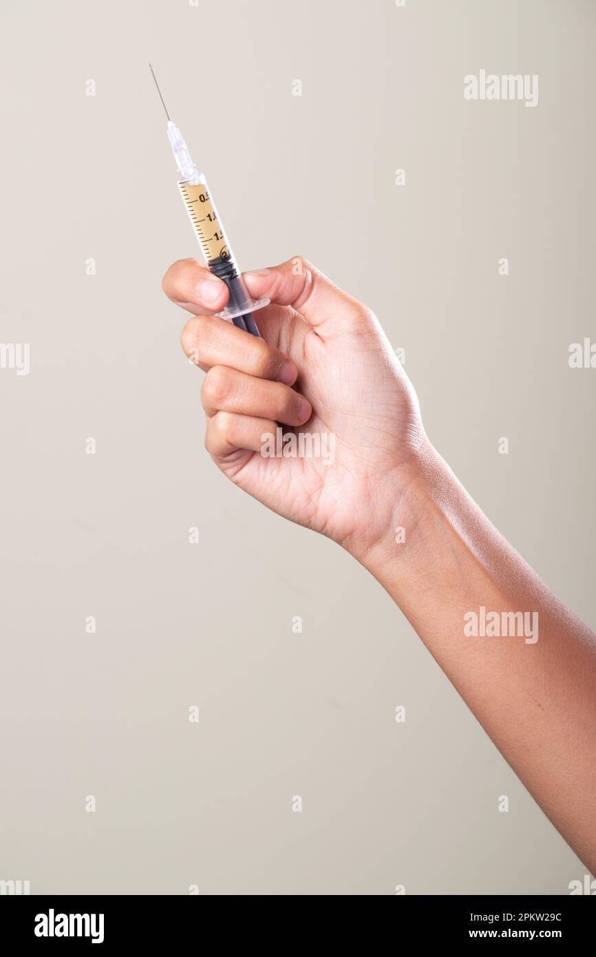 Injection in hand on grey background Stock Photo - Alamy