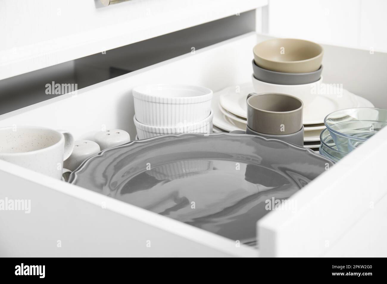 Open drawer of kitchen cabinet with different dishware, closeup Stock ...