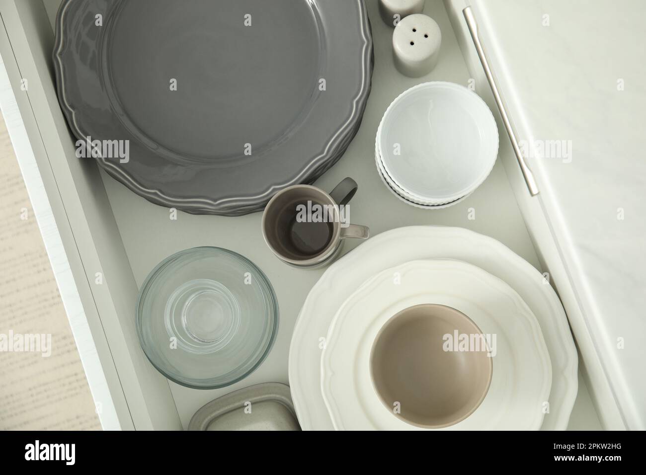 Open drawer of kitchen cabinet with different dishware, top view Stock ...