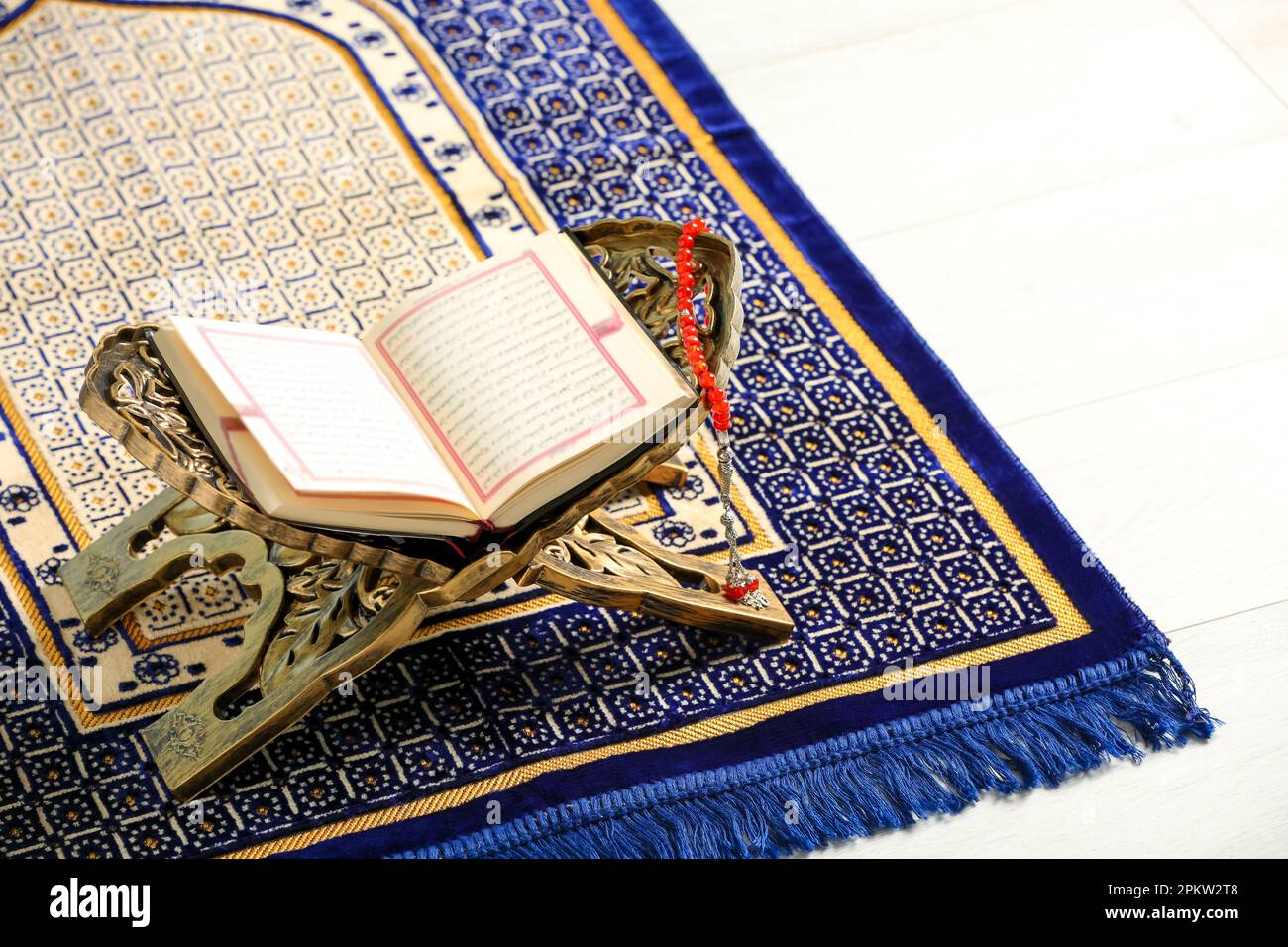 Rehal with open Quran and Misbaha on Muslim prayer rug, space for text ...