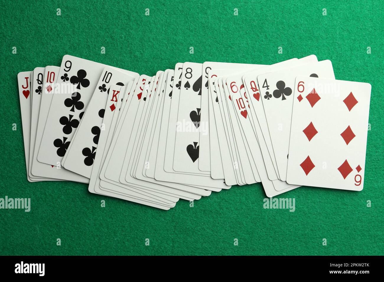 Deck of playing cards on green table, top view. Poker game Stock Photo ...