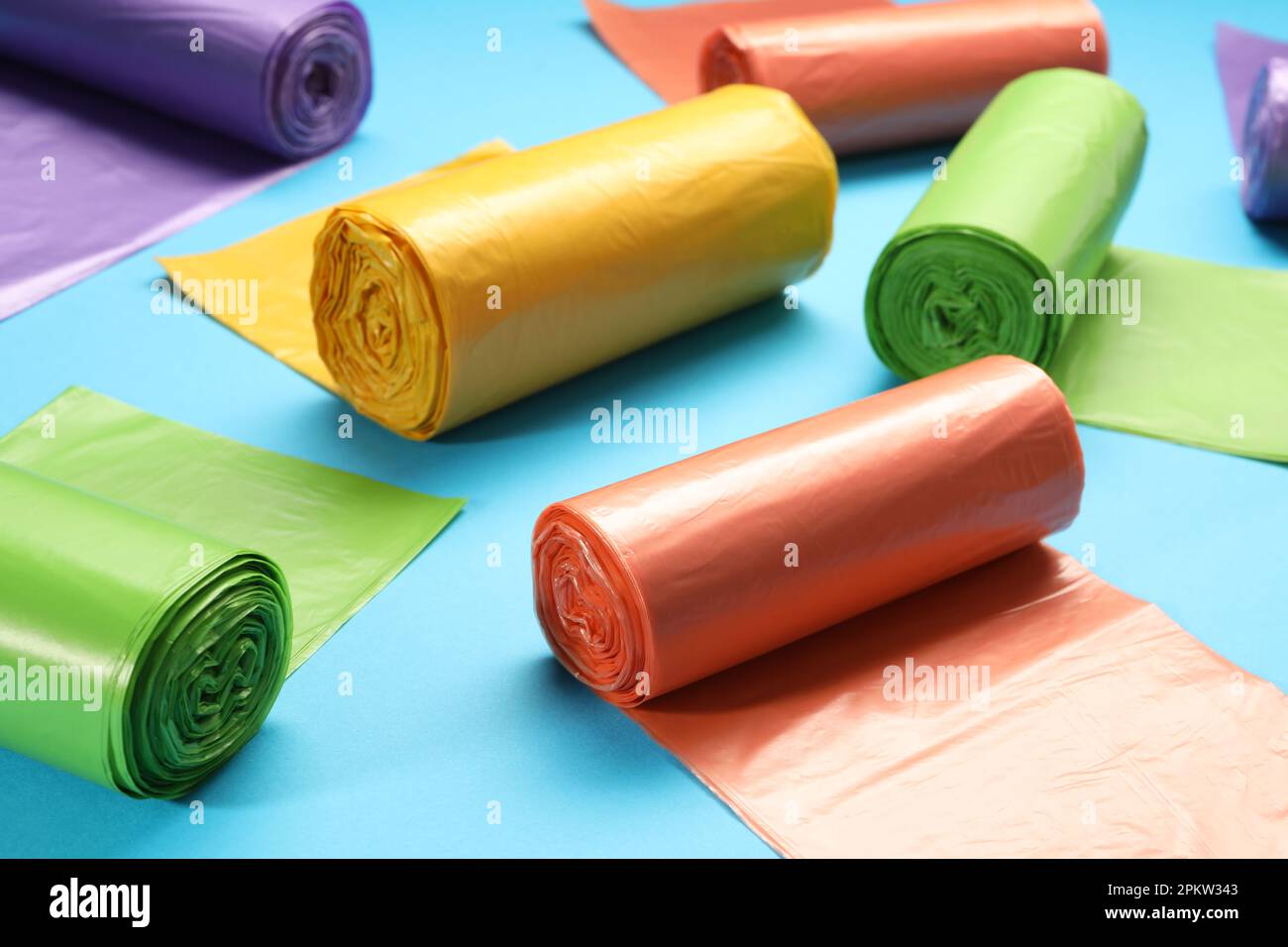 Rolls of different garbage bags on light blue background Stock Photo ...