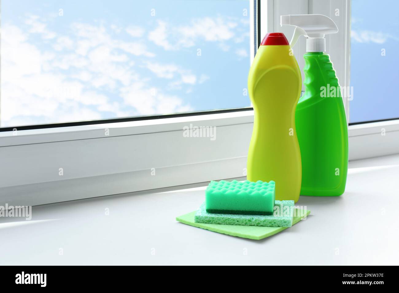 Cleaning supplies and sponges on window sill indoors, space for text ...