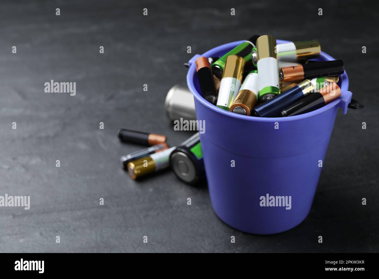 Used batteries and bucket on black table, space for text Stock Photo ...