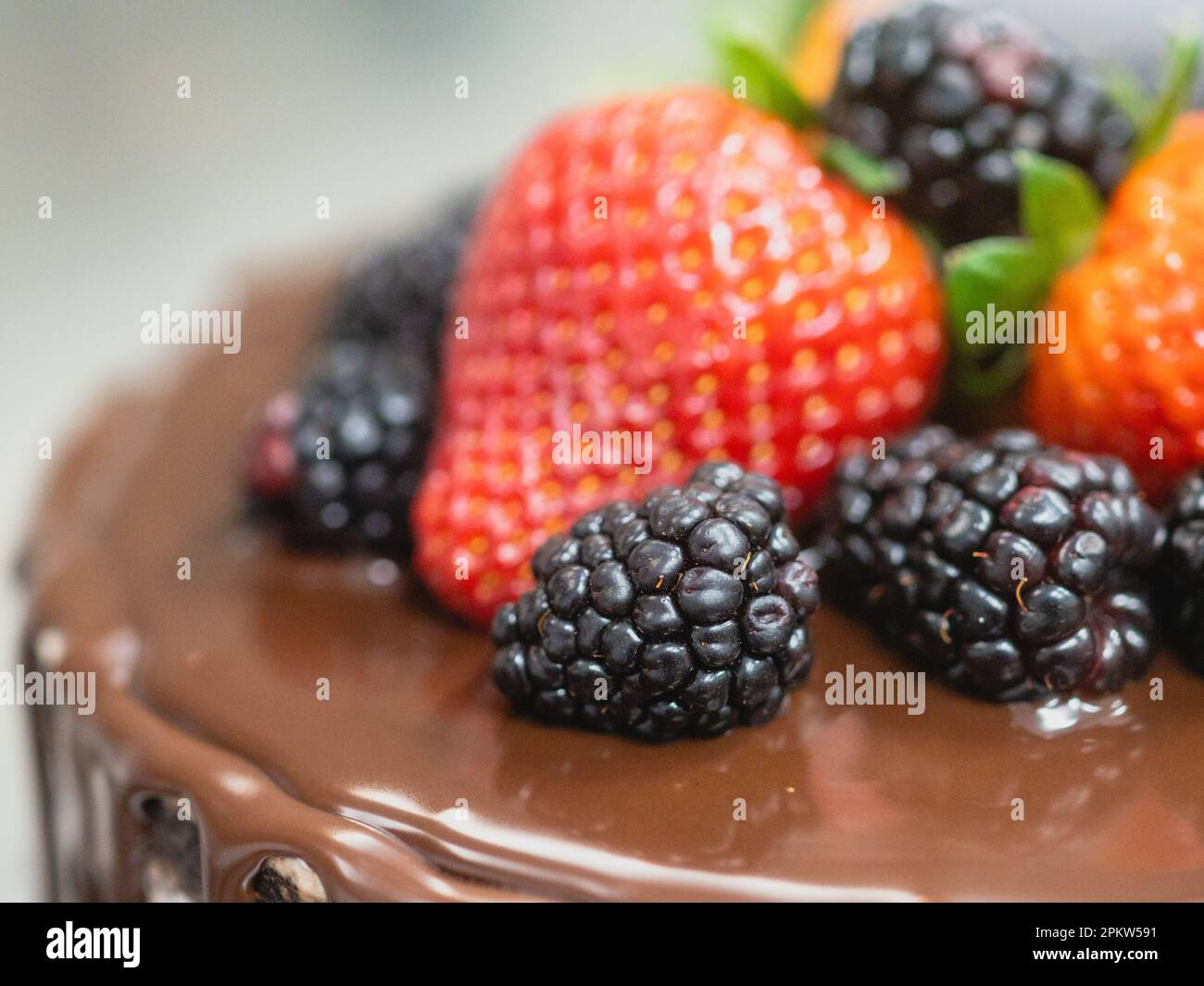 pastry chef preparing a chocolate frosted dripped icing cup cake with ...