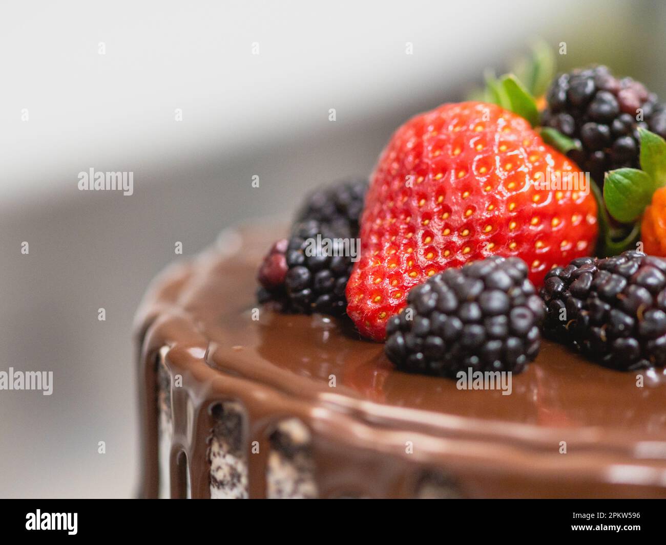pastry chef preparing a chocolate frosted dripped icing cup cake with ...