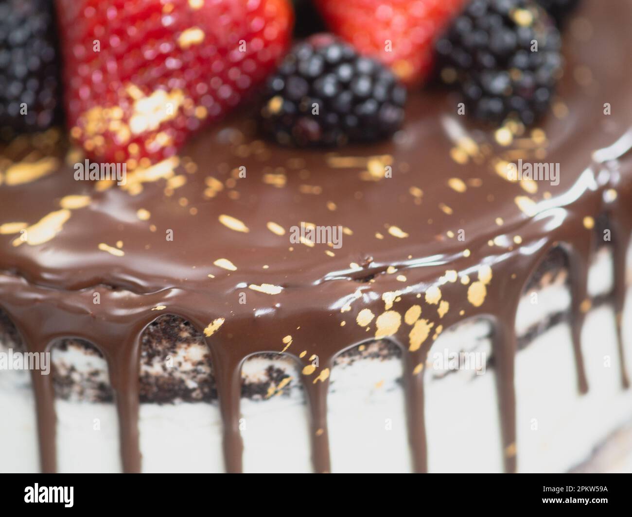 pastry chef preparing a chocolate frosted dripped icing cup cake with ...