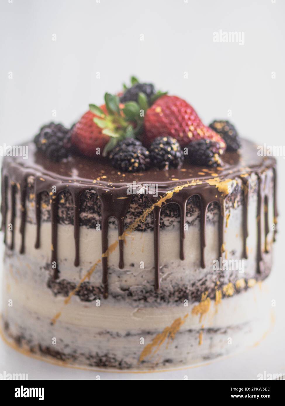 studio shot of chocolate frosted dripped icing cup cake with sweet ...