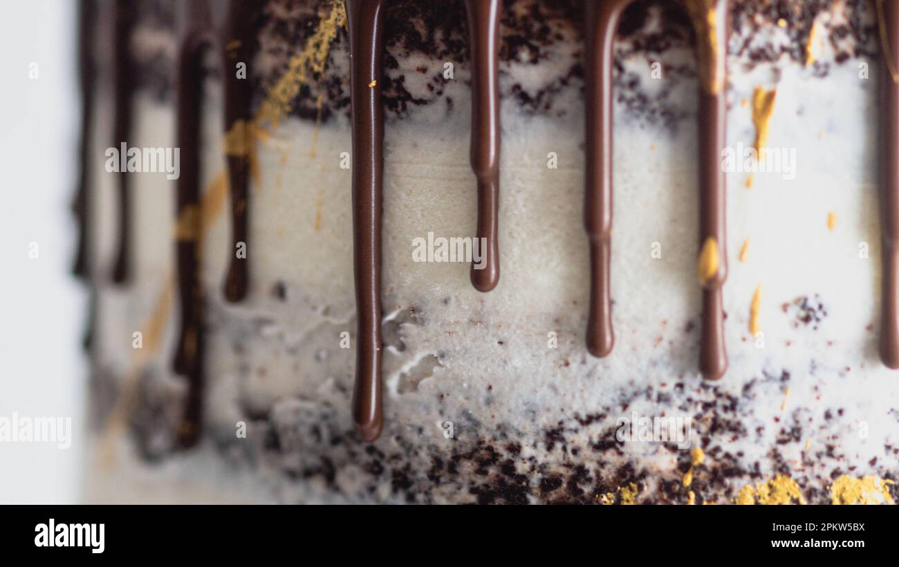 studio shot of chocolate frosted dripped icing cup cake with sweet ...