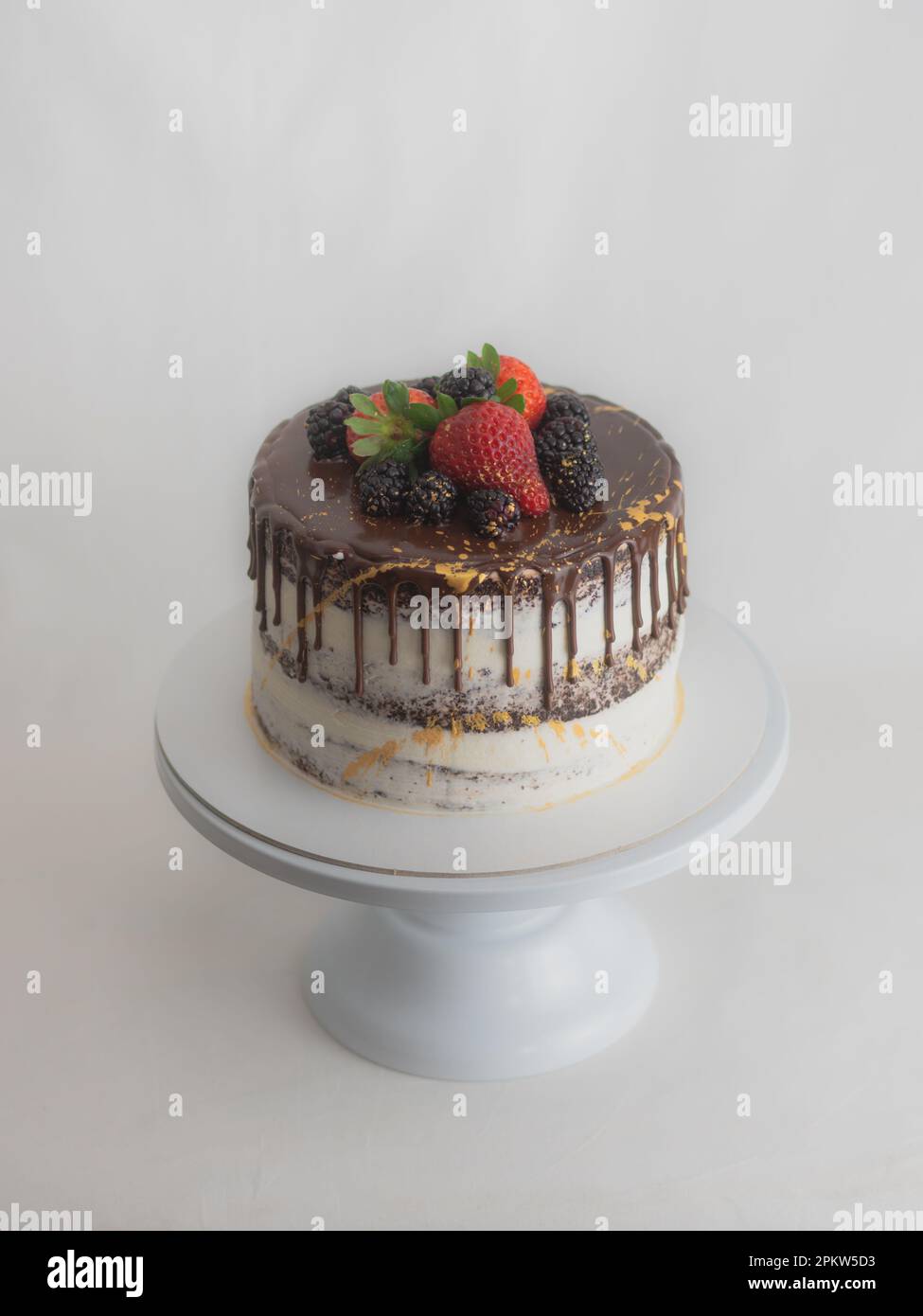 studio shot of chocolate frosted dripped icing cup cake with sweet ...