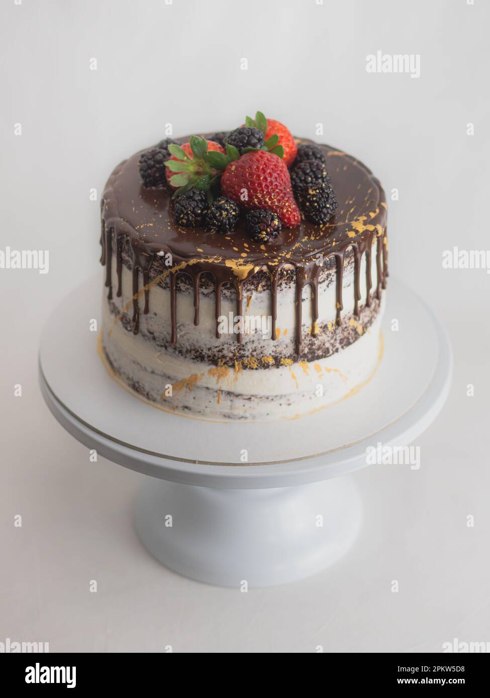 studio shot of chocolate frosted dripped icing cup cake with sweet ...