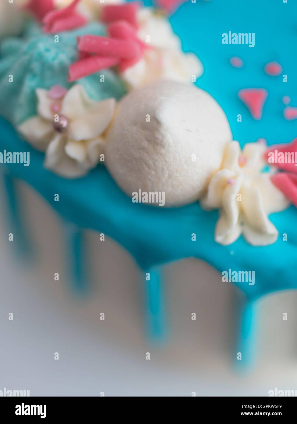 studio shot of chocolate frosted blue dripped icing white cup cake ...