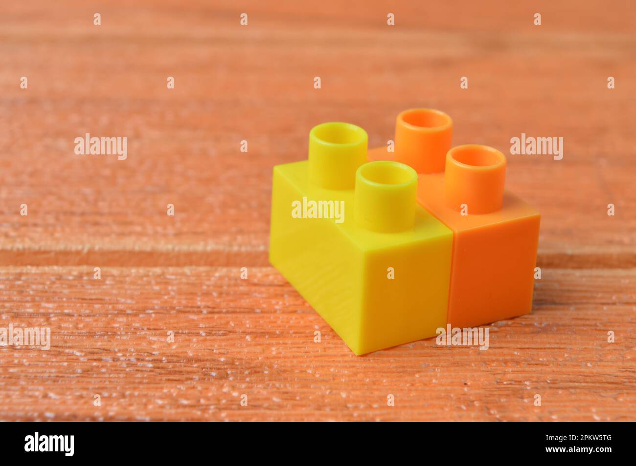 Toy building block isolated on a brown background Stock Photo - Alamy