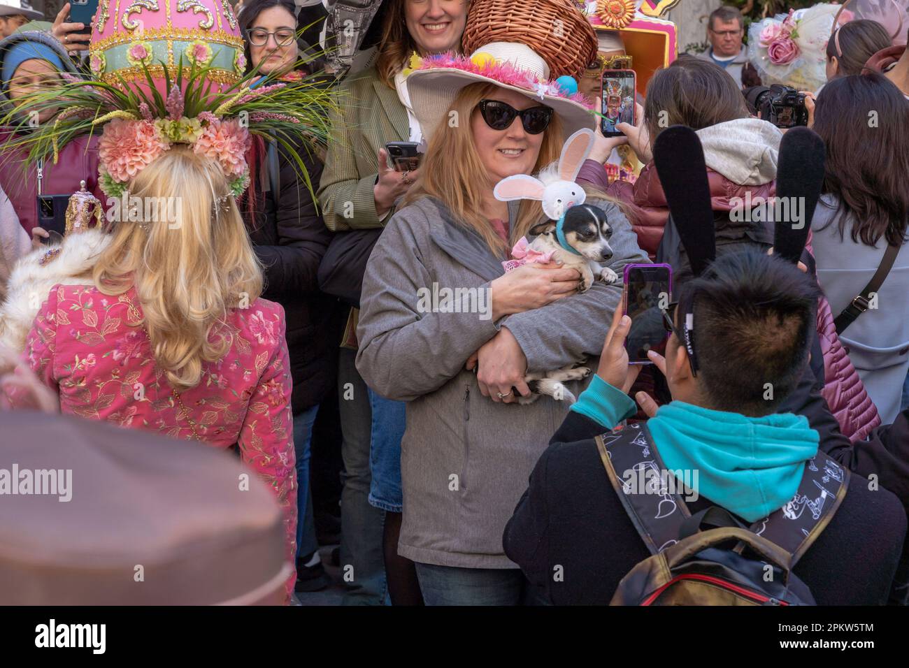 NEW YORK, NEW YORK - APRIL 09: A woman holds a dog during the Easter Parade and Bonnet Festival ...